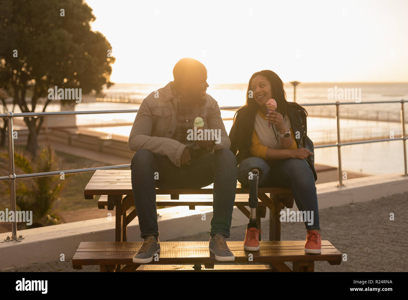 Couple having ice cream on promenade bench Stock Photo - Alamy
