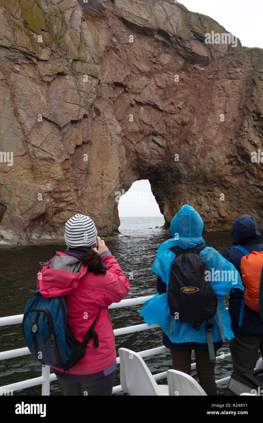 Tourists view and photograph the Arch in Perce Rock off the Gaspe ...