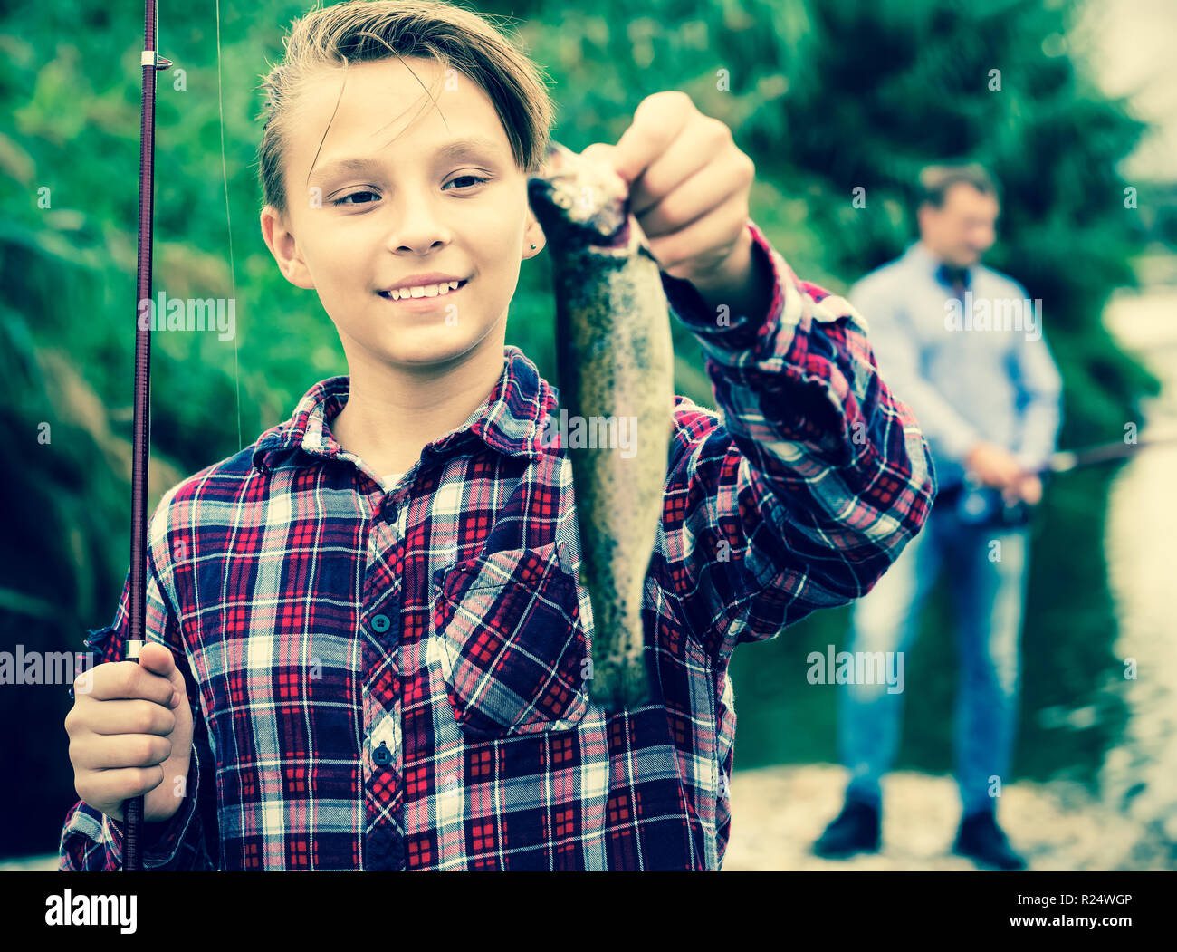 Happy teenager boy showing catch fish he holding in hands Stock Photo ...