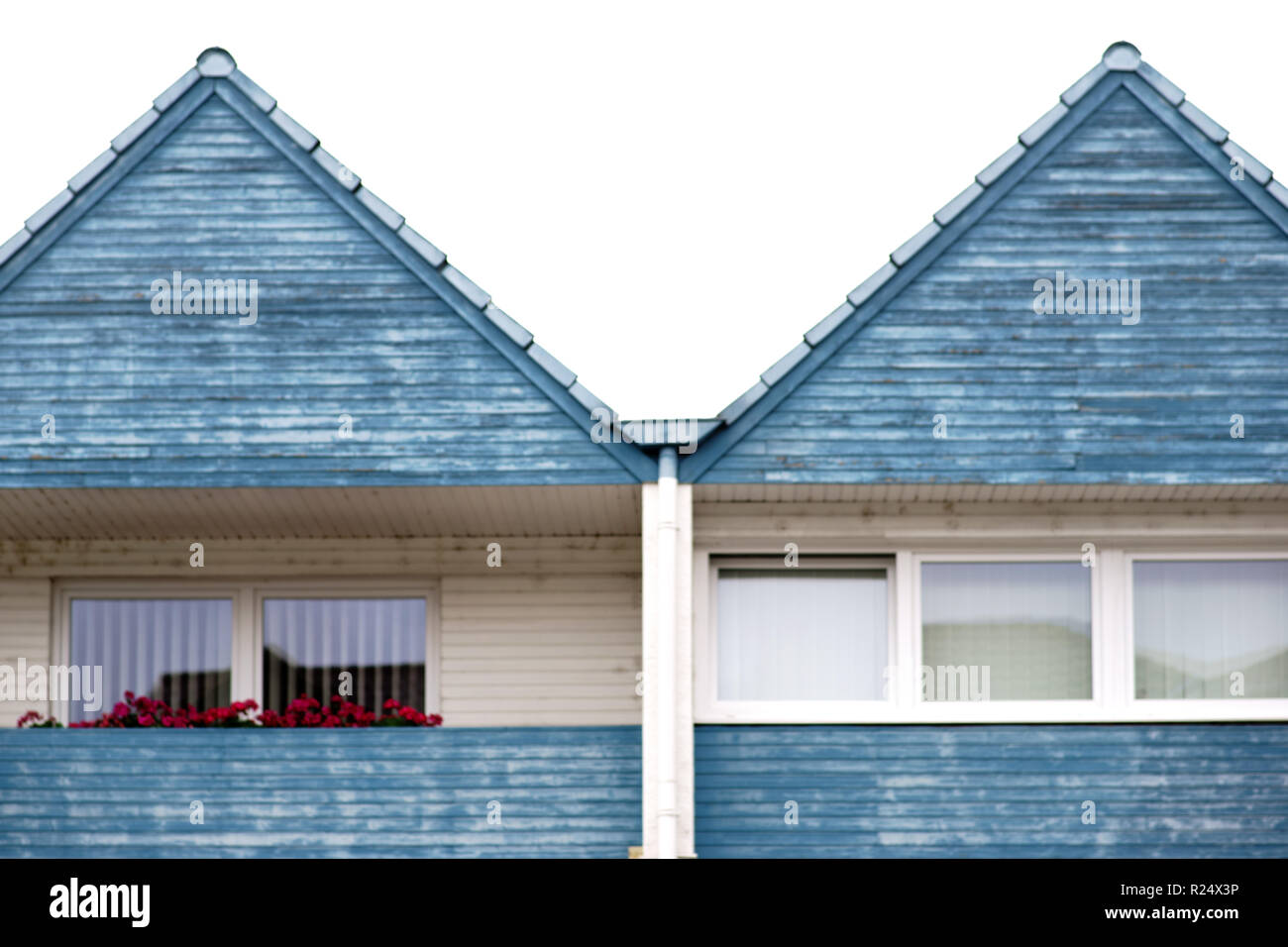 The roof gable of a terraced house with a wooden board facade and a ...