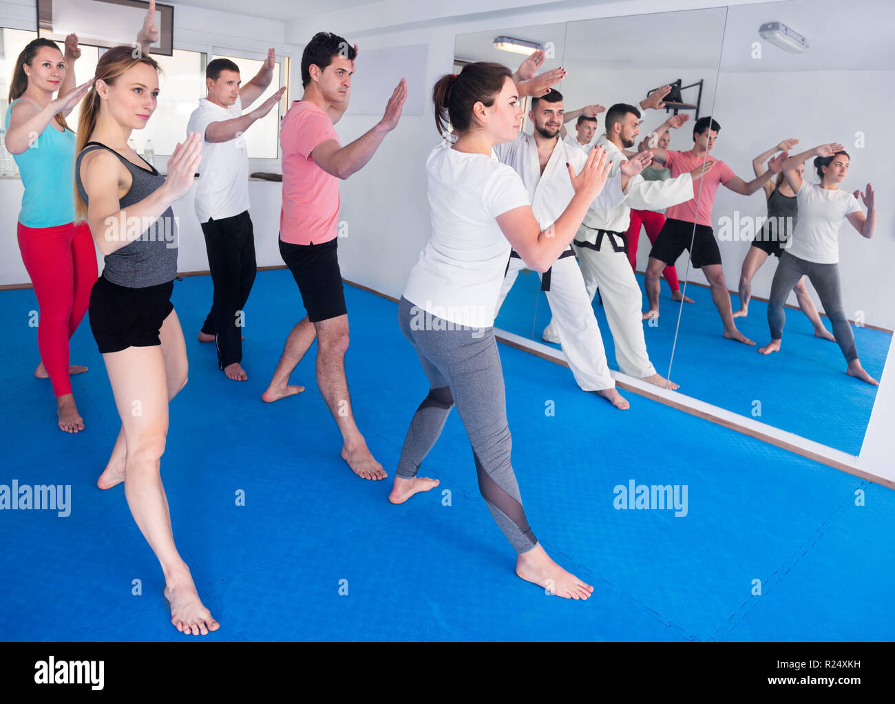 Young adult trainees practicing new maneuvers in karate class Stock ...