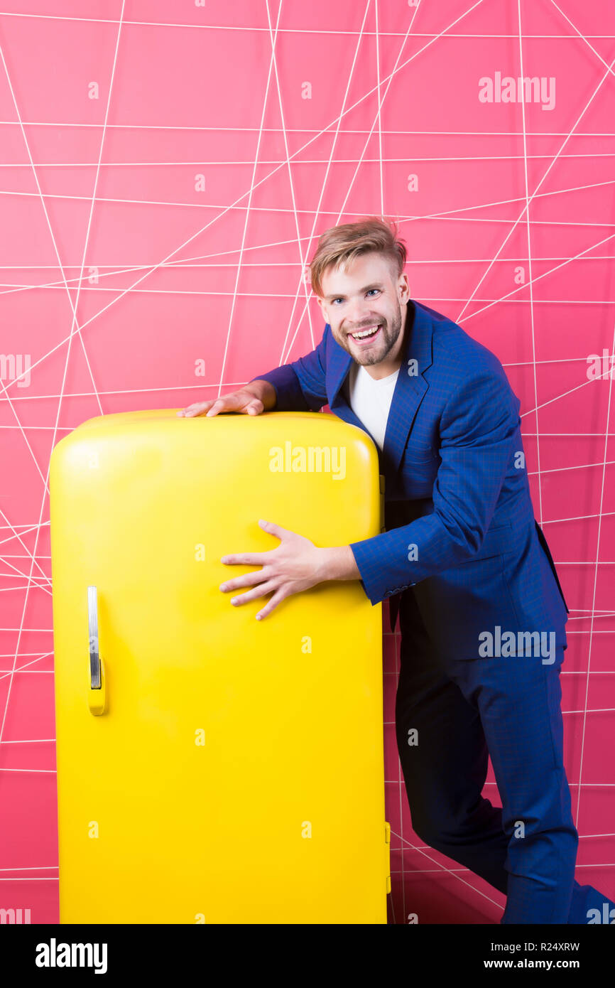 Man formal elegant suit stand near retro vintage yellow refrigerator ...