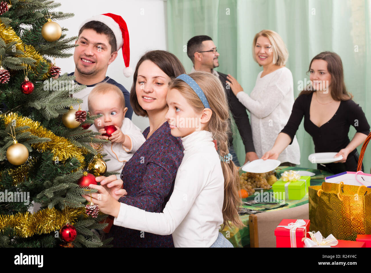 Happy big family with presents and Christmas tree at the table at home ...