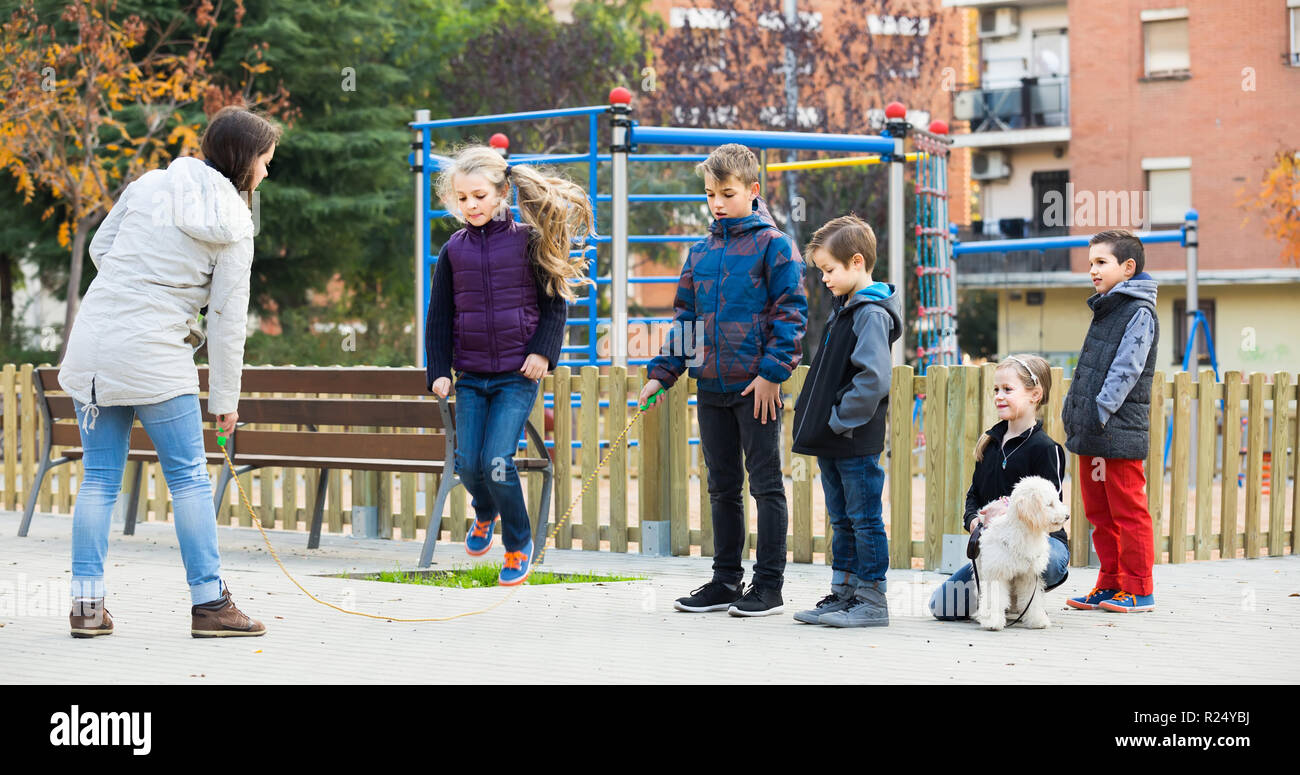 happy spanish children playing rubber band jumping game and laughing ...