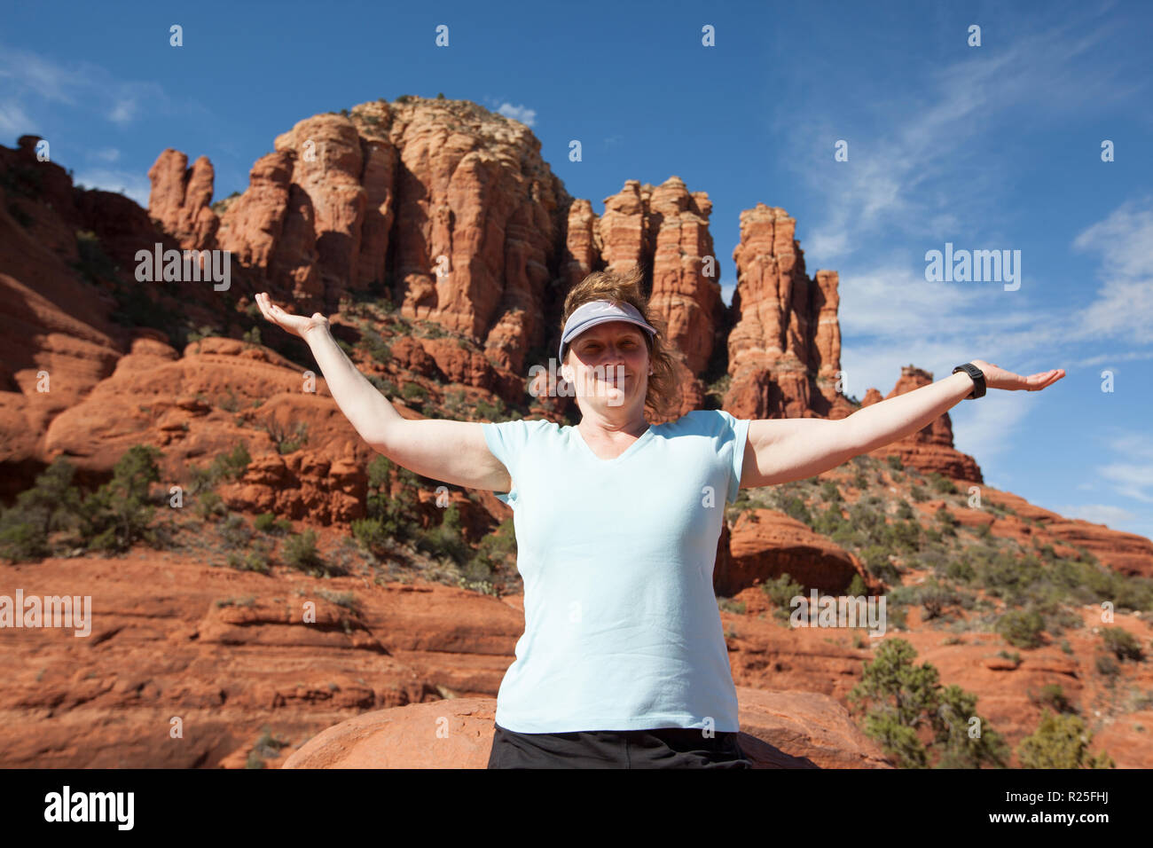 woman hiker raises arms at the peak of chicken point in sedona arizona ...