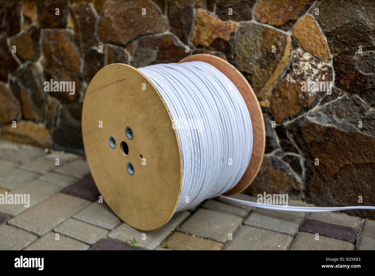 Big roll of white industrial electrical cable on large wooden reel ...