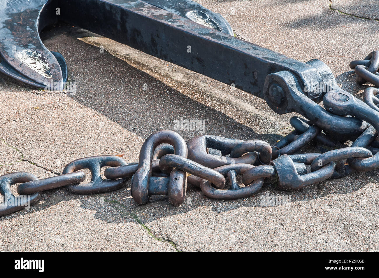 Heavy iron metal ship anchor with chain on gray asphalt Stock Photo - Alamy