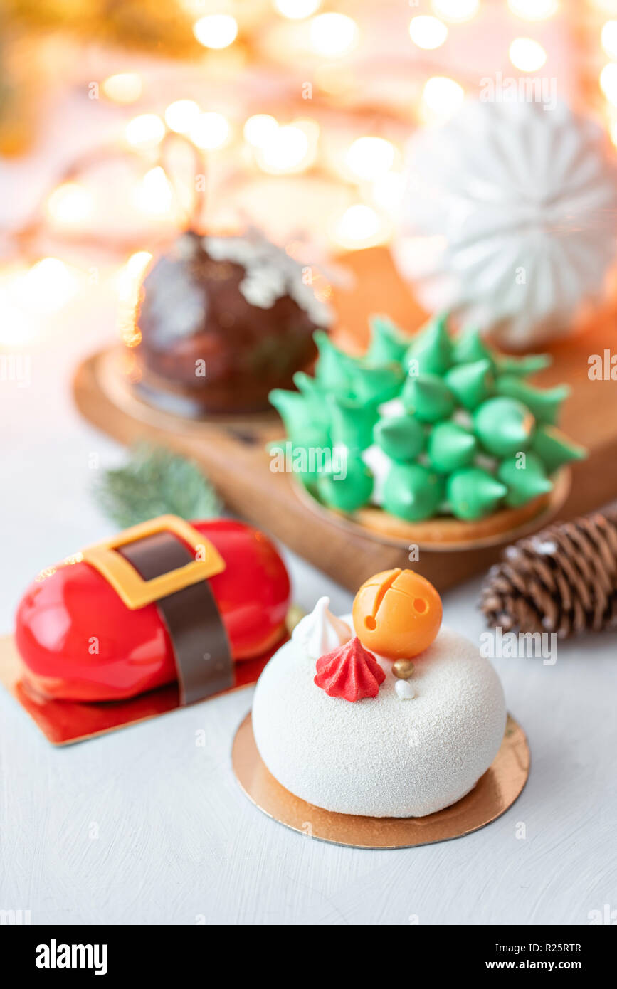 Mini mousse pastry desserts covered with velour or glaze. Garland lamps ...