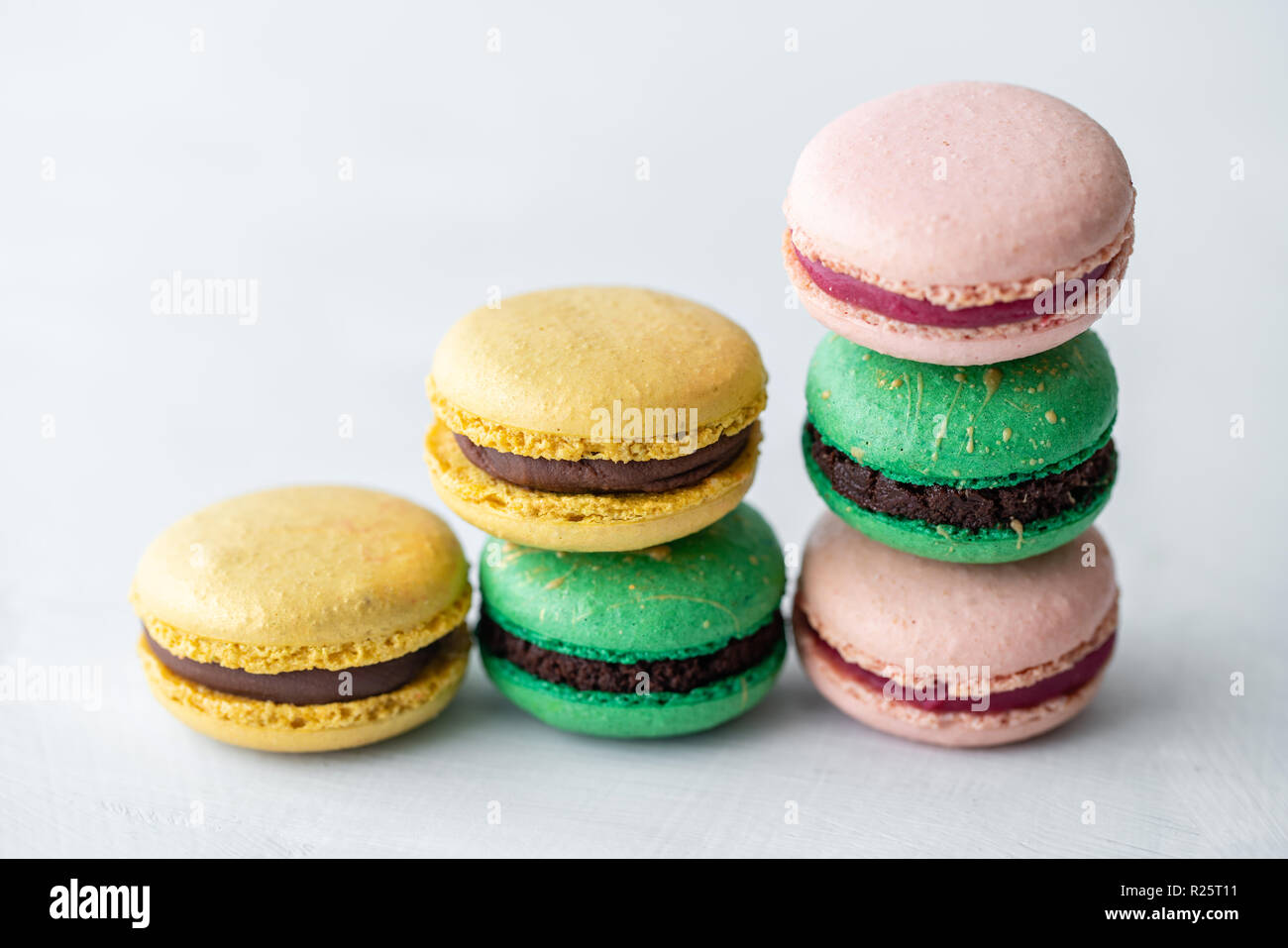 Variety of sweet macaroons are stacks on gray table. Modern european ...