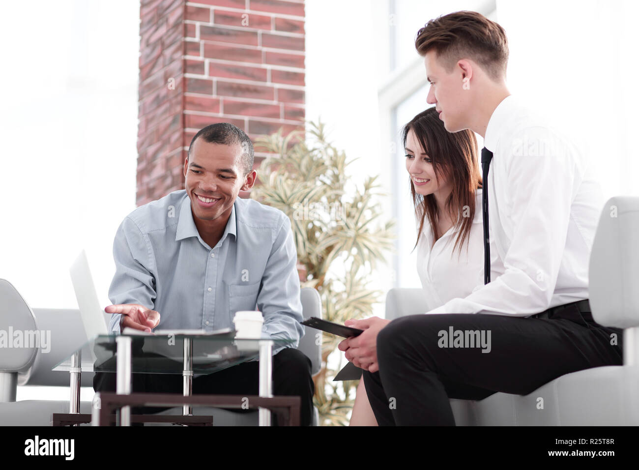 business team looking at laptop screen,sitting behind a Desk Stock ...