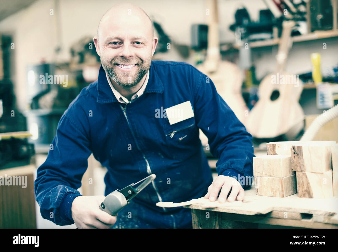 Portrait of smiling professional woodworker on lathe at musical ...