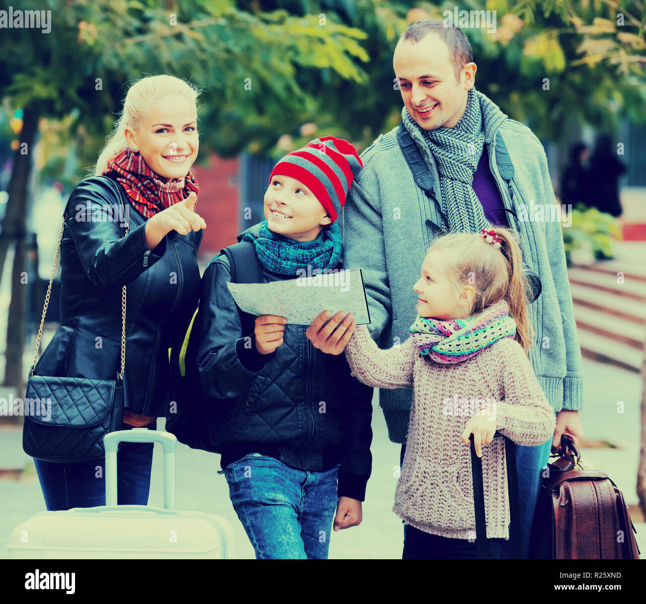 Happy smiling parents with two kids and baggage using urban map Stock ...