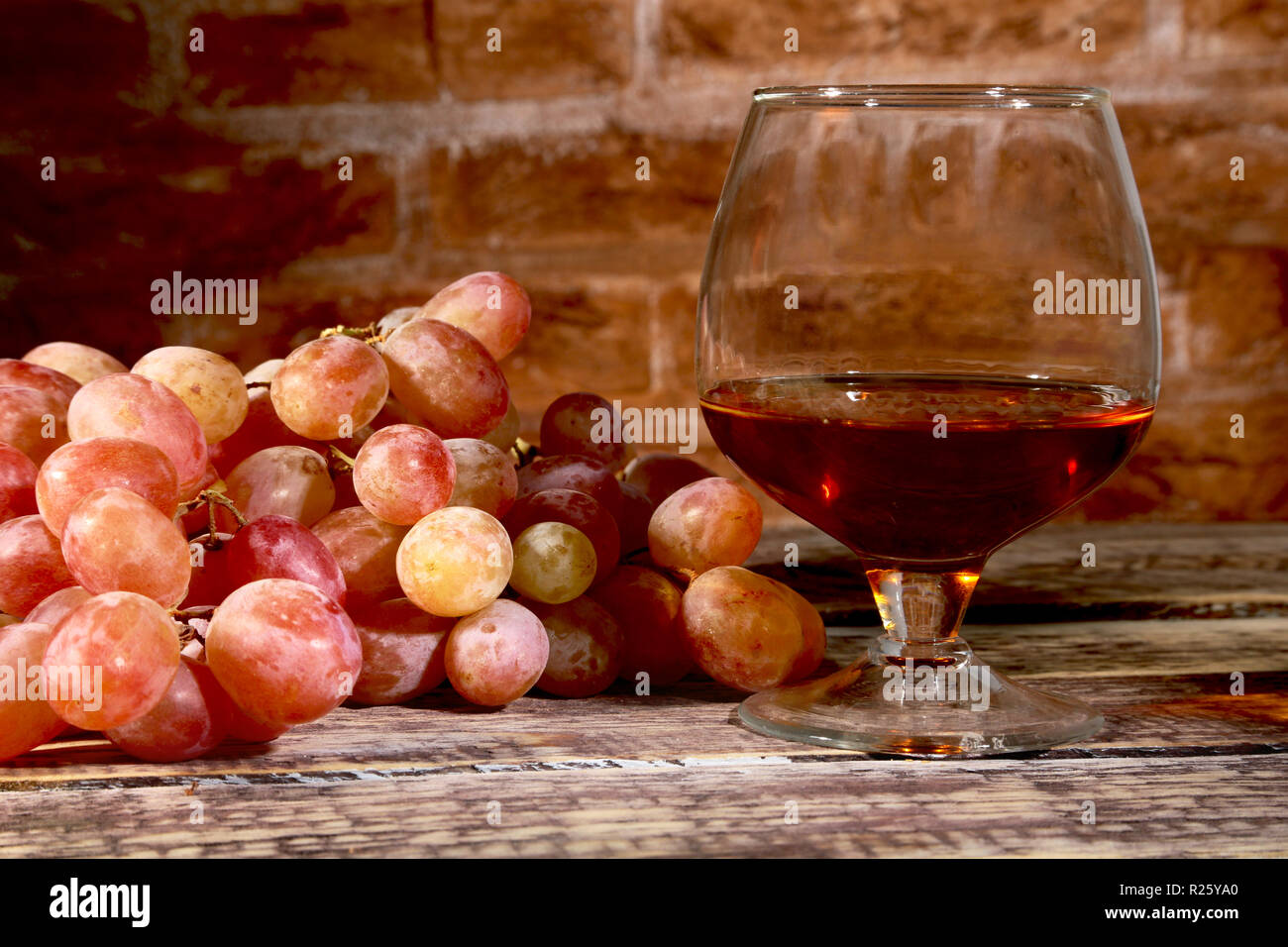 Cognac or Brandy in a glass and fresh grapes, still life in rustic ...