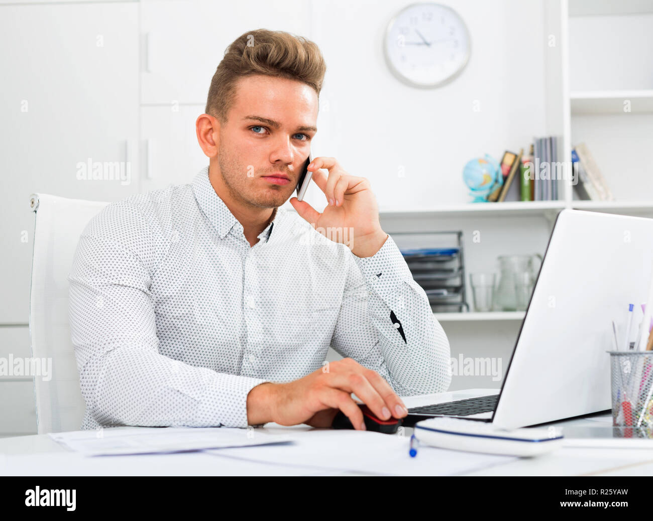 Positive business partner with smart phone and laptop in agency Stock ...