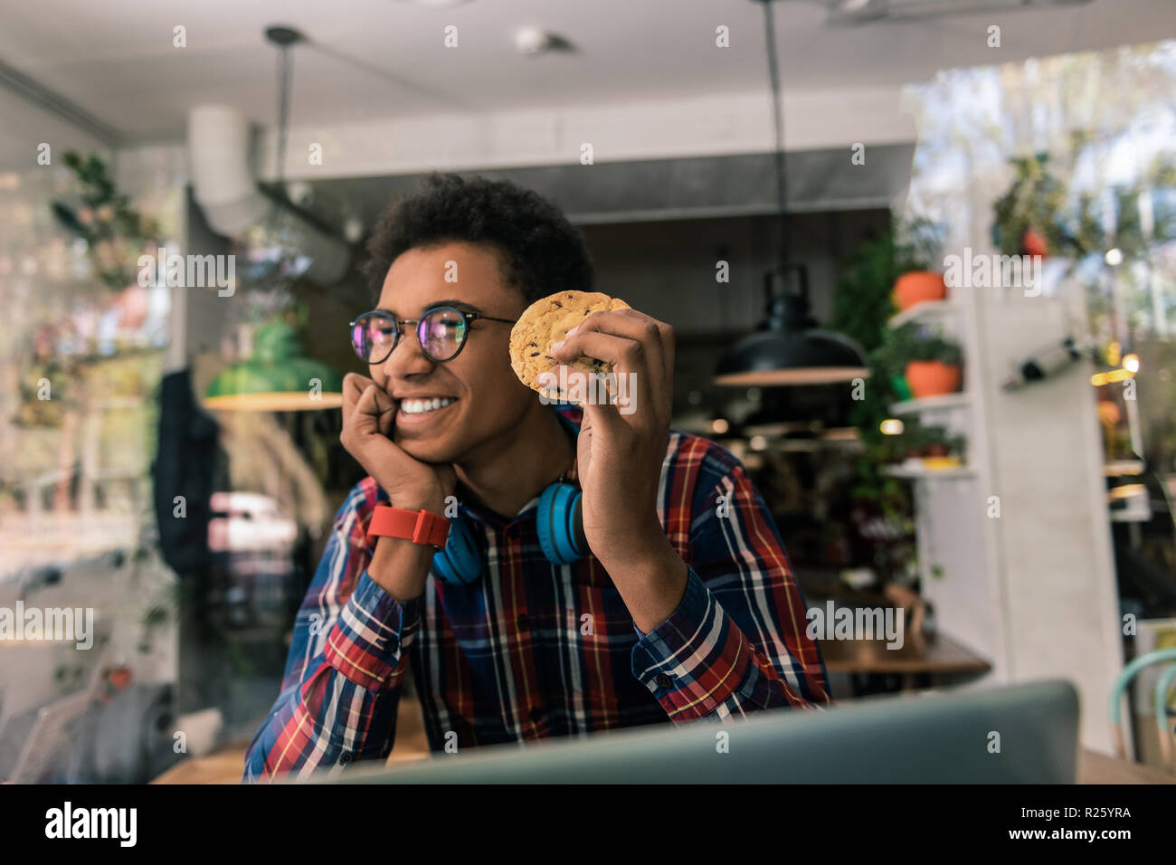 Happy delighted man eating a tasty cookie Stock Photo - Alamy