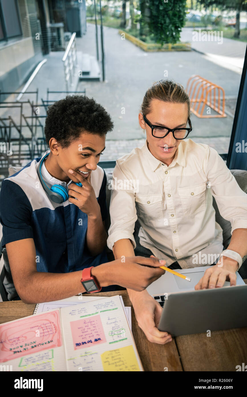 Joyful afro American man pointing at the screen Stock Photo - Alamy