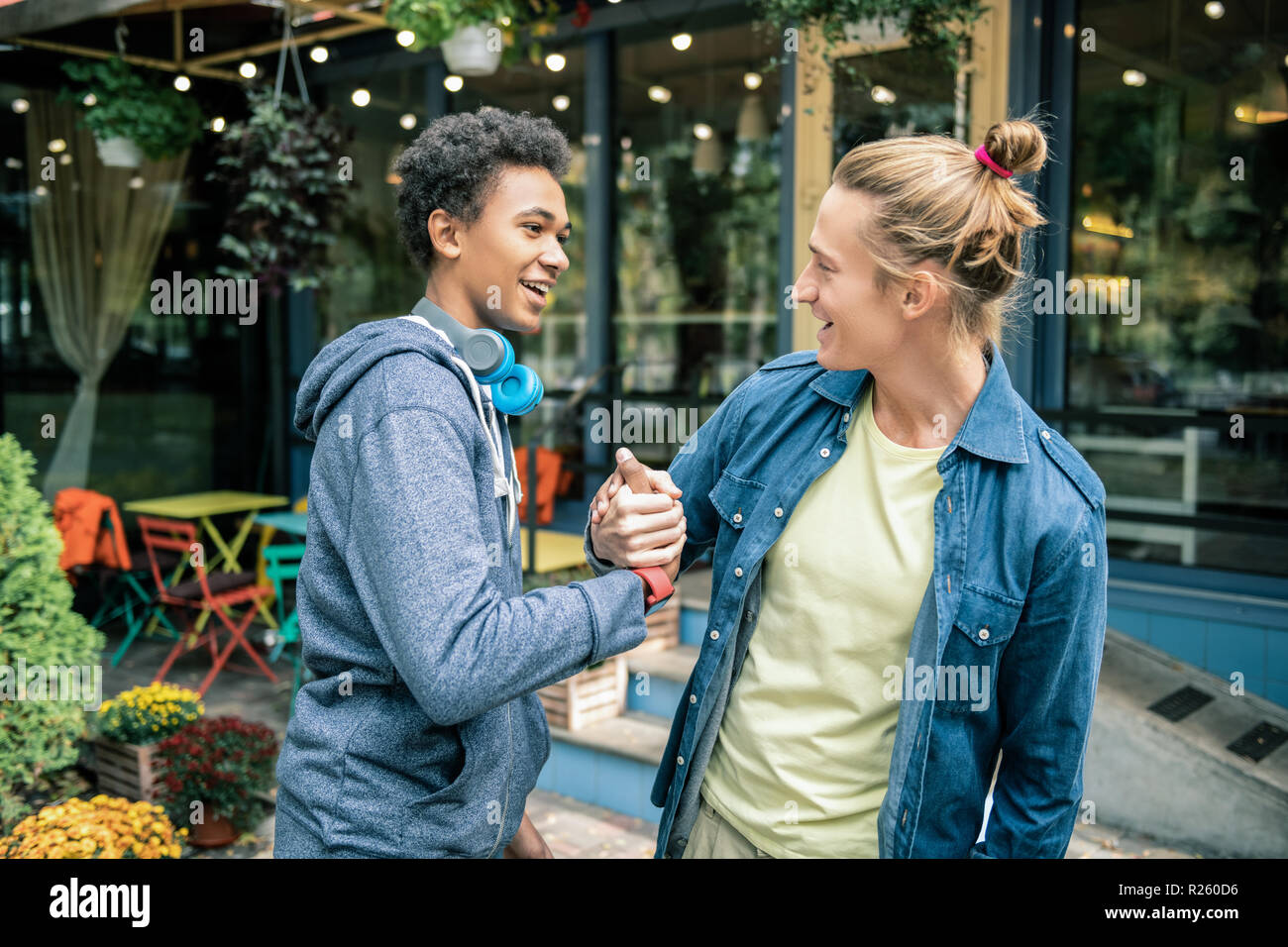 Positive young man greeting his best friend Stock Photo - Alamy