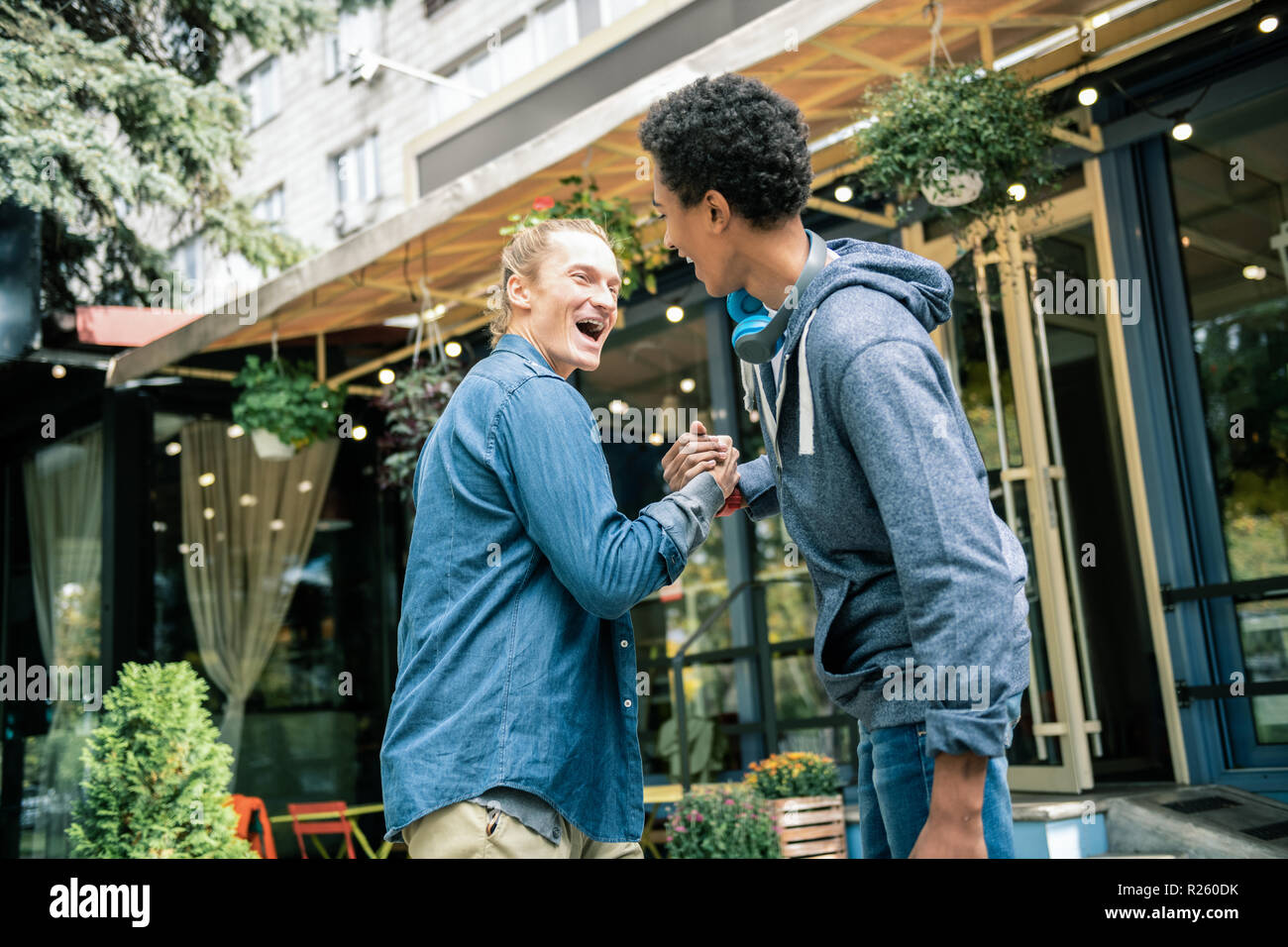 Happy nice young men greeting each other Stock Photo - Alamy