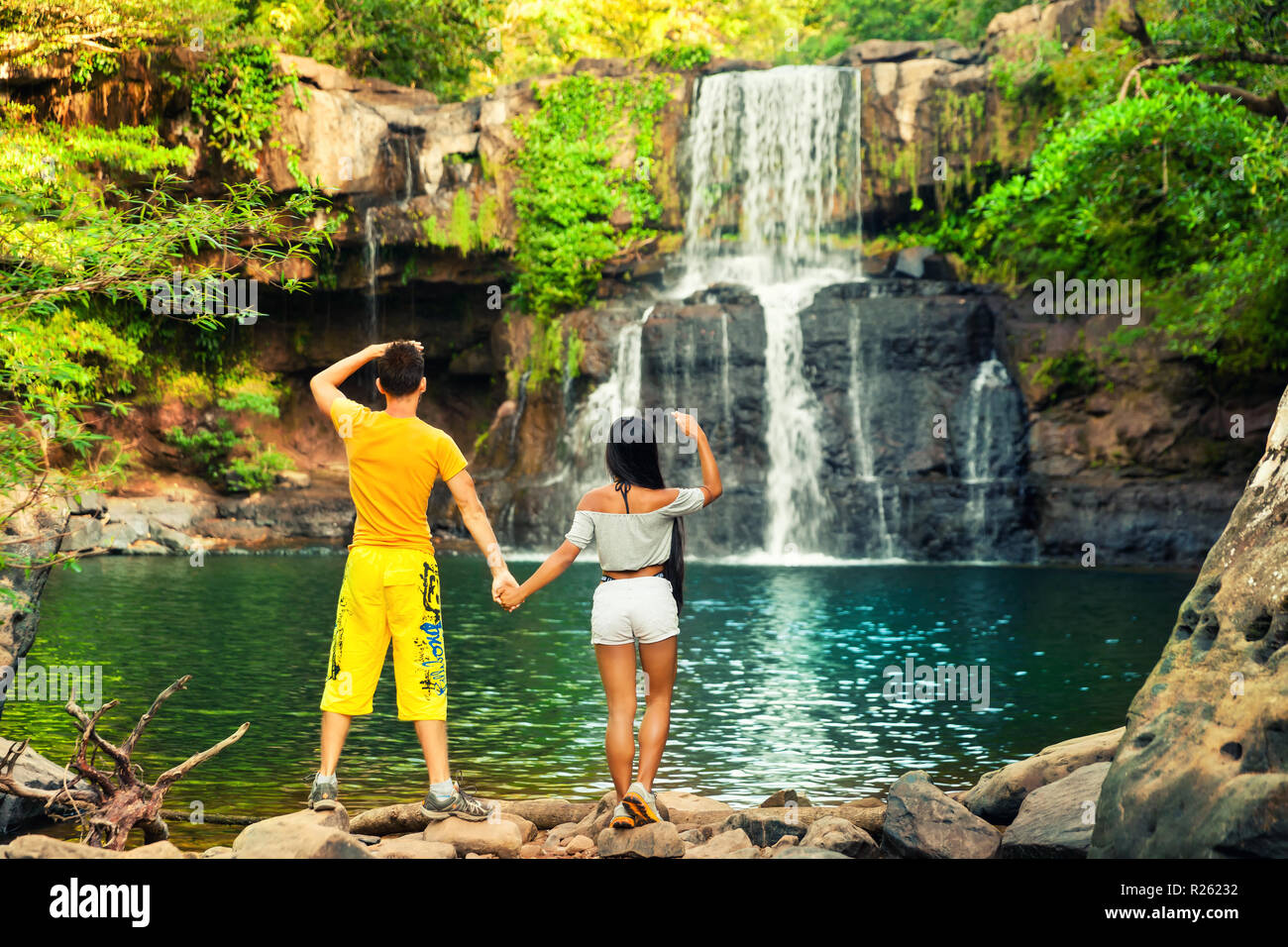 A loving couple traveler people enjoy amazing view waterfall hidden in ...