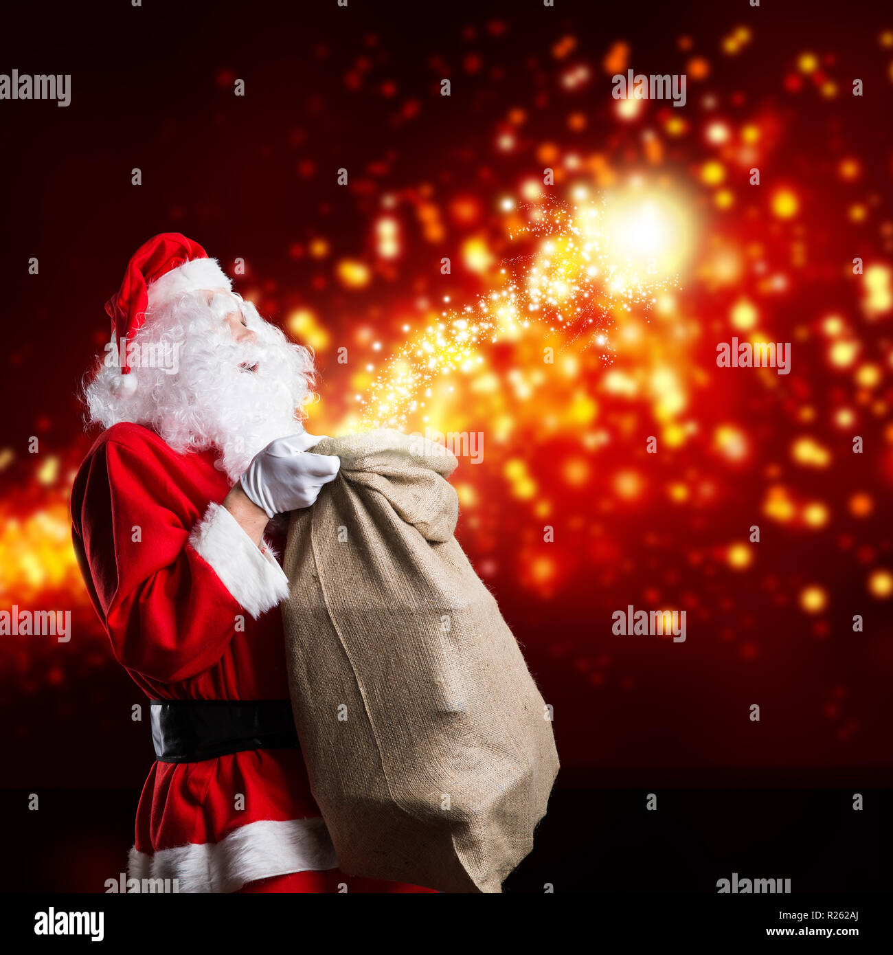Santa Claus releases some twinkling christmas magic Stock Photo - Alamy