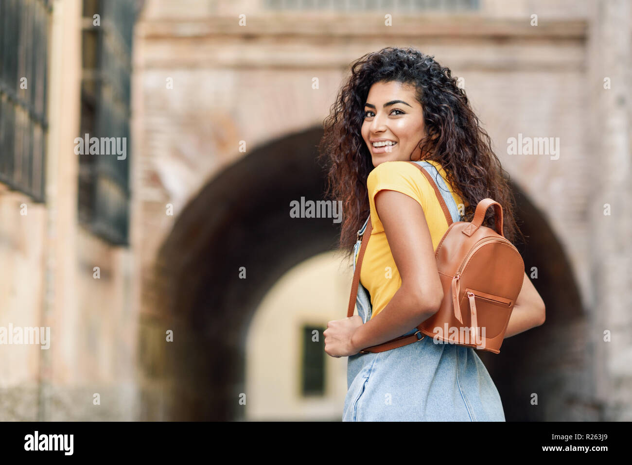 Rear view of young Arab woman with backpack outdoors. Traveler girl in ...