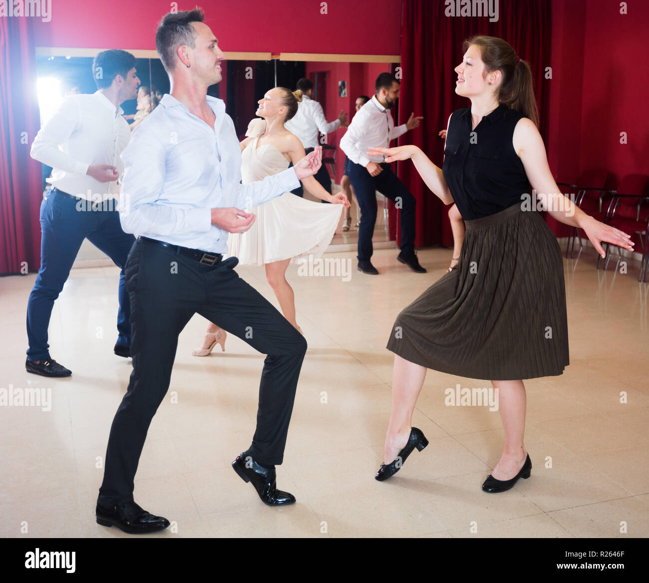 Young positive people dancing twist in pairs Stock Photo - Alamy