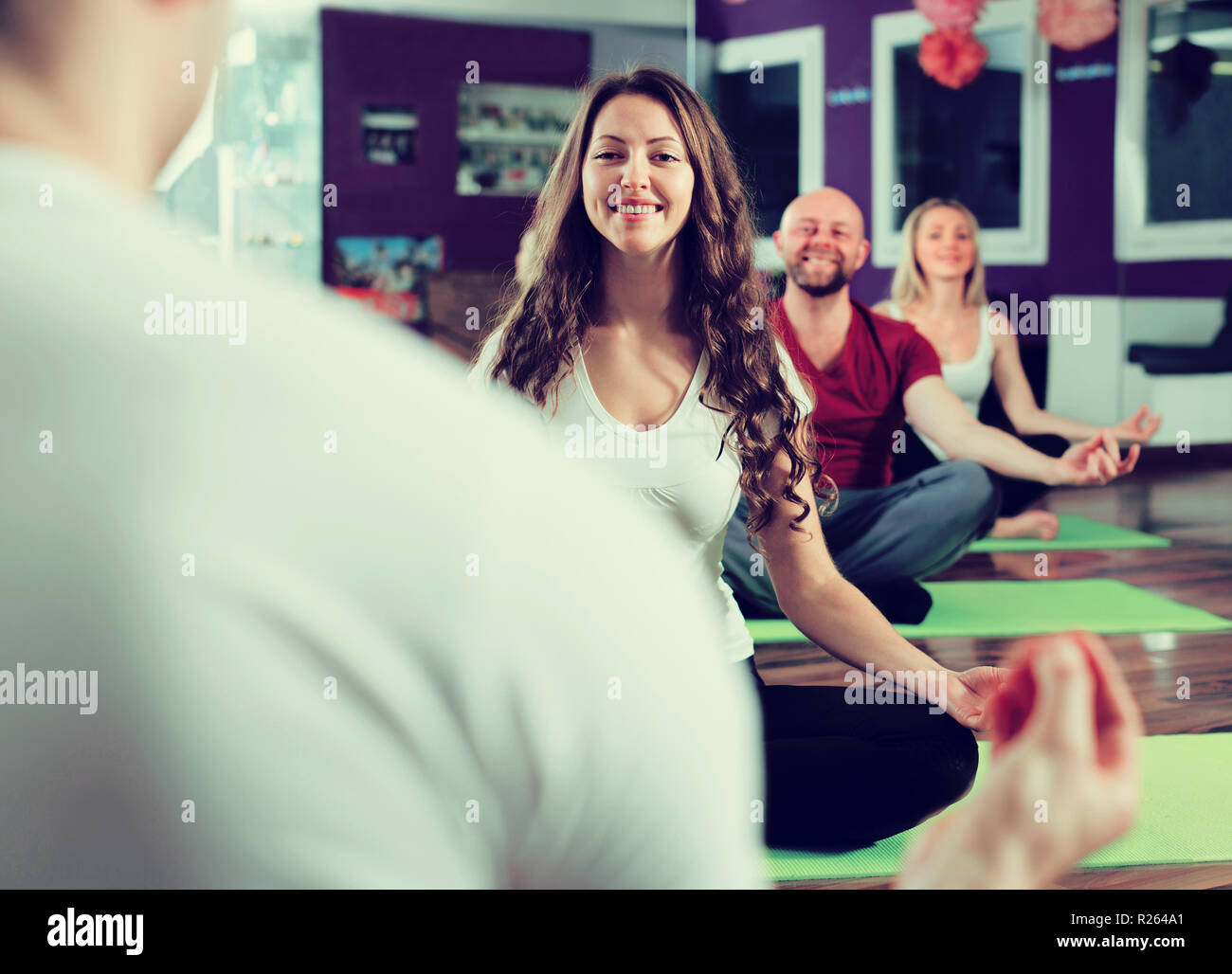 Coach showing to adult russian learners new yoga posture at class Stock ...