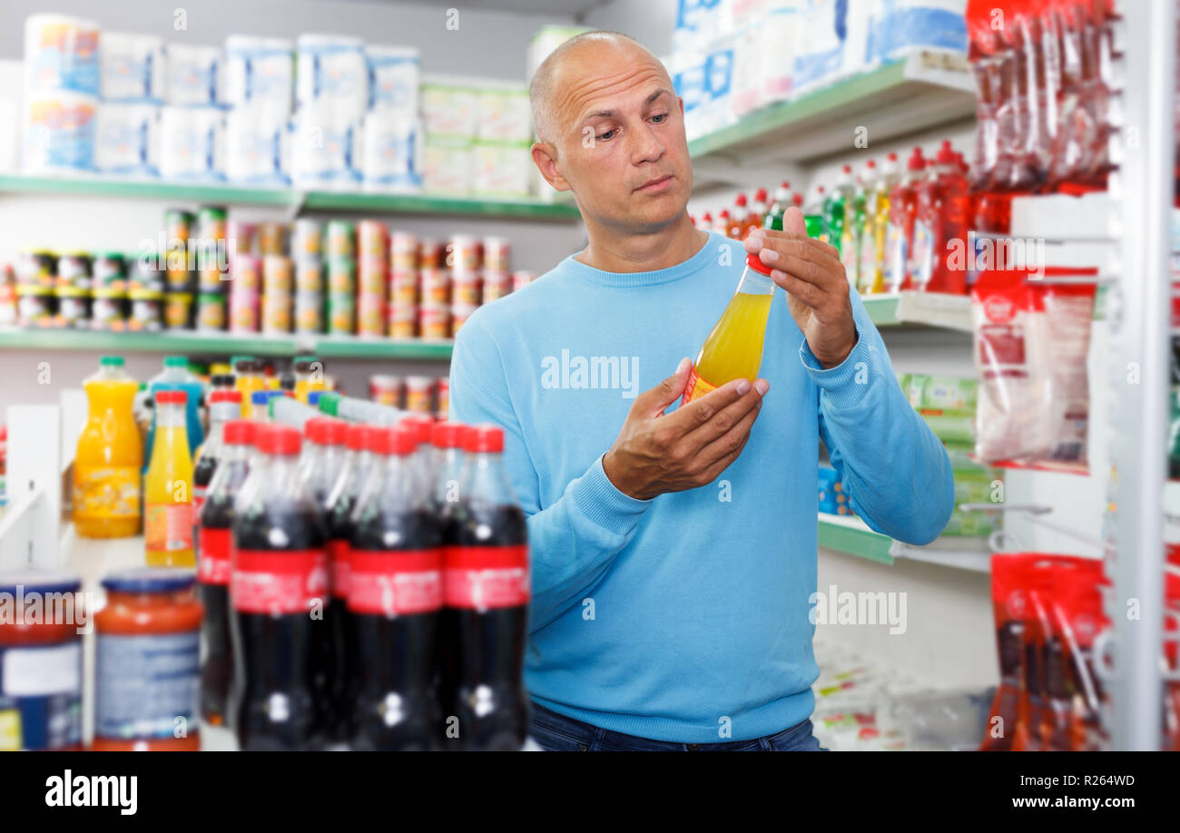 Positive male customer buying food products in grocery store Stock ...