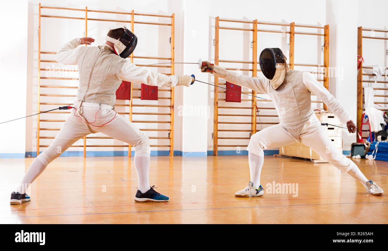 Group of fencers at fencing workout, exercising the techniques in the ...