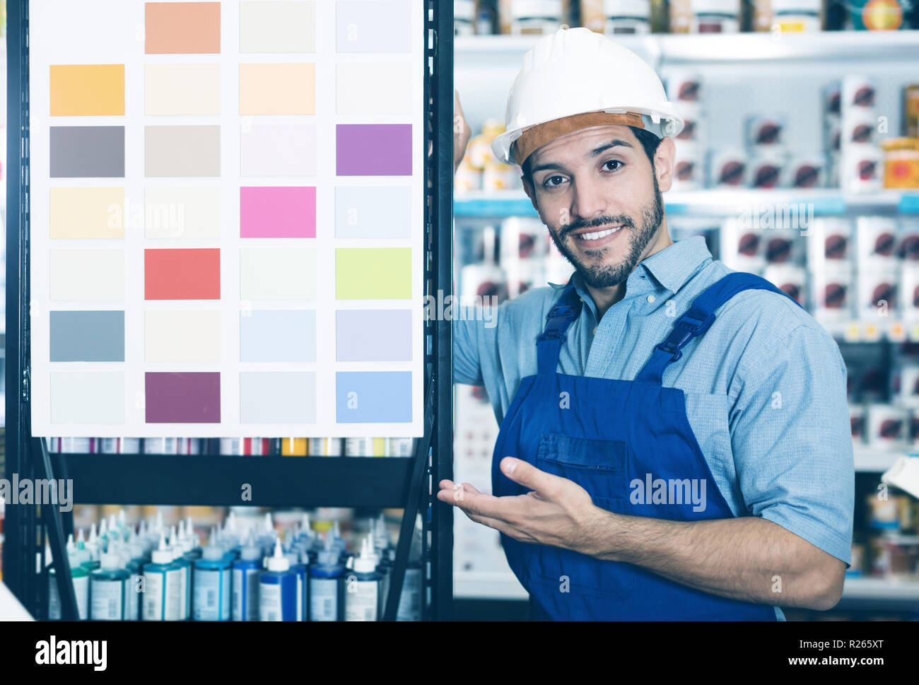 Happy workman standing near stand with samples in paint store Stock ...