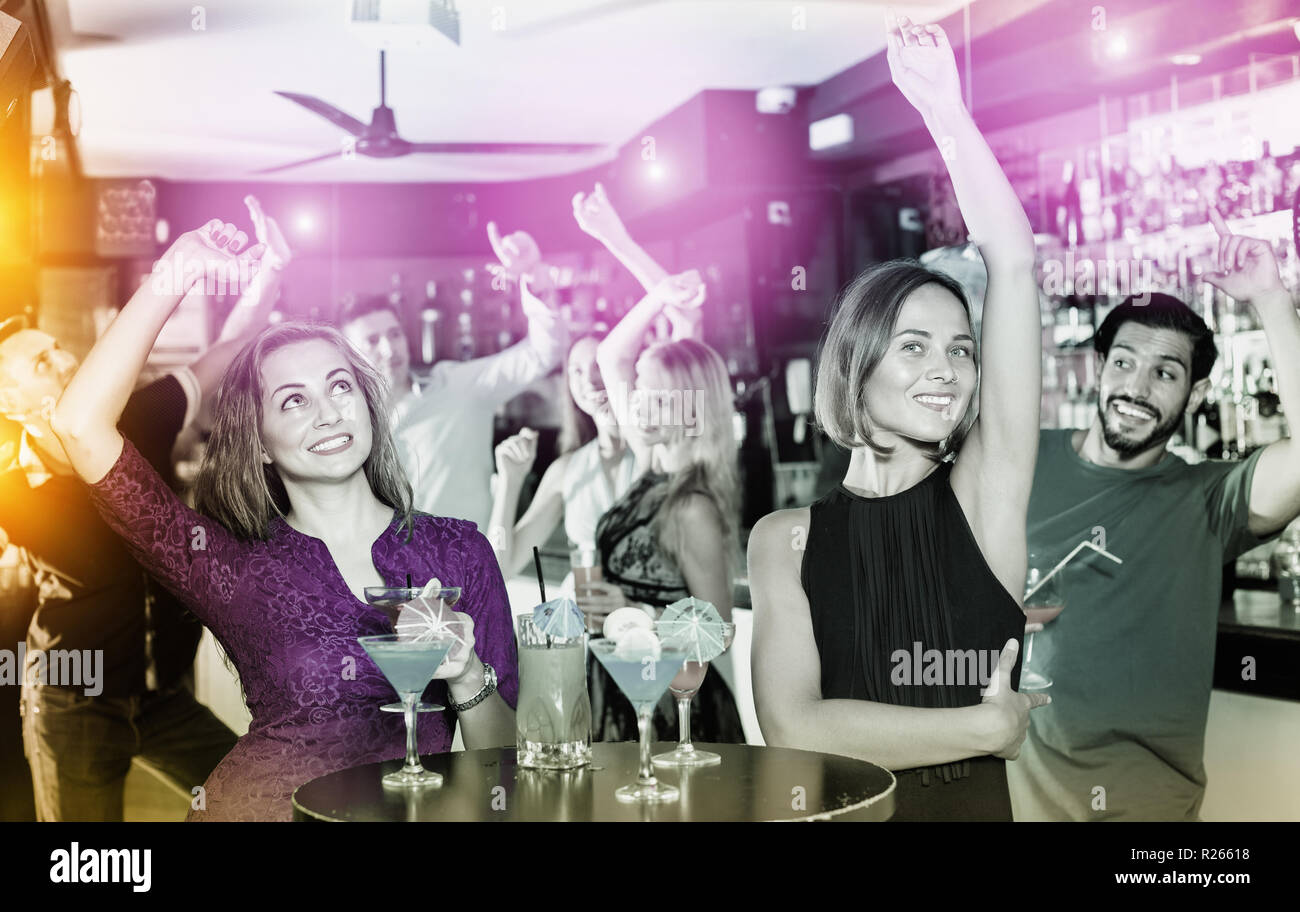 Happy cheerful positive women are drinking cocktails and having fun in ...