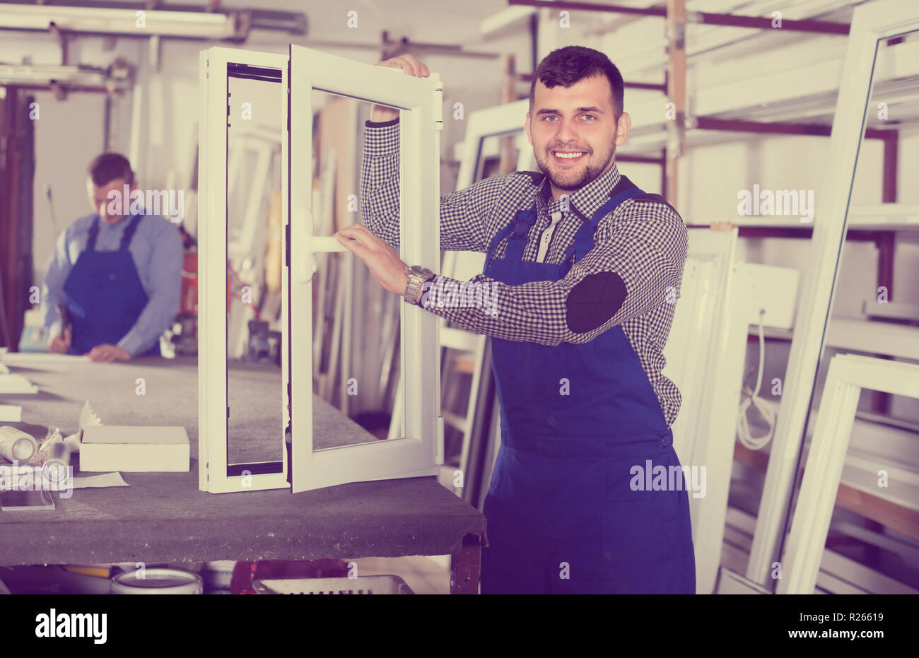 Workman is demonstrating the window frame in workshop Stock Photo - Alamy