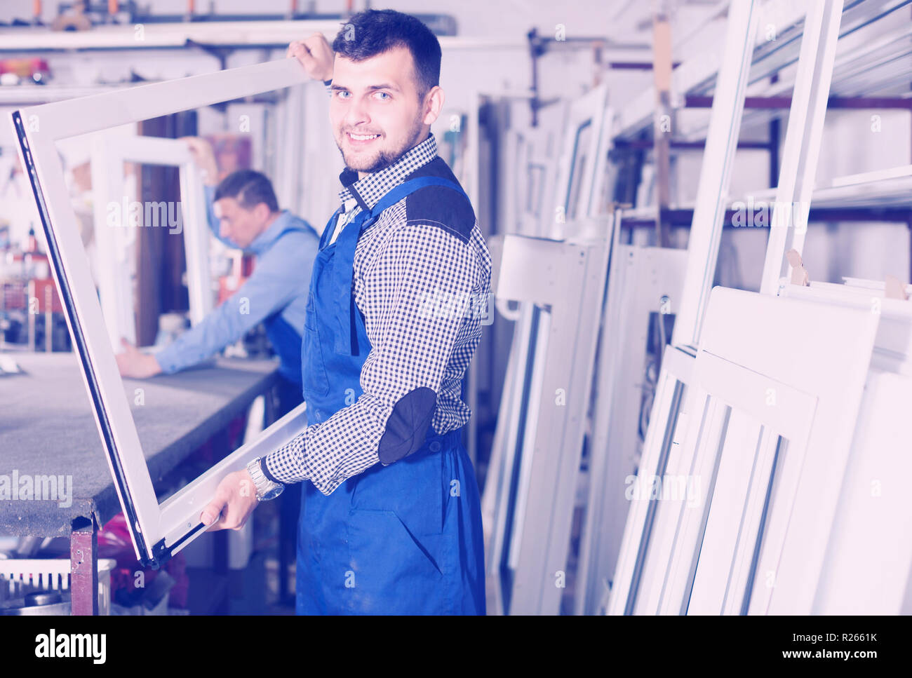 Young man worker is demonstrating PVC manufacturing output in workshop ...