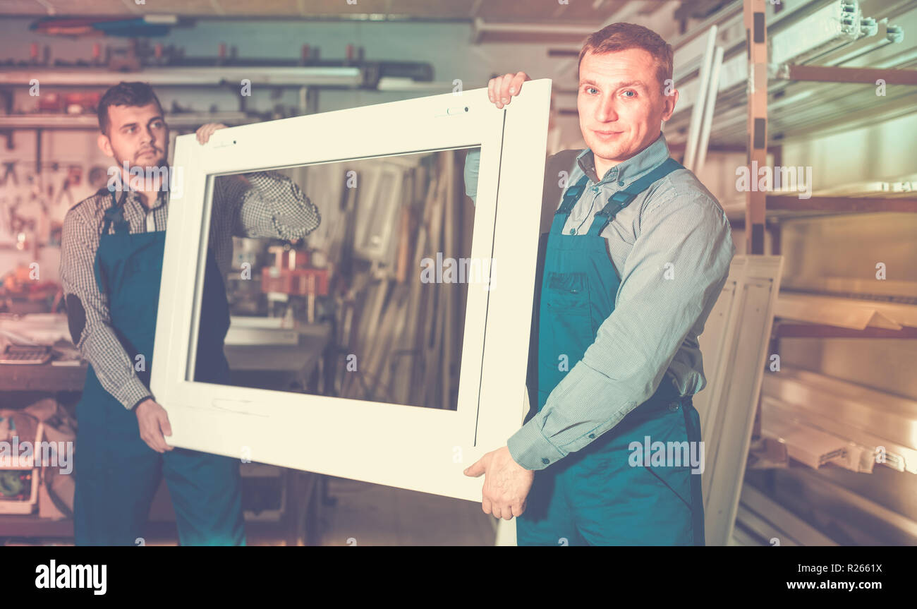 Production smiling american workers in coverall with different finished ...