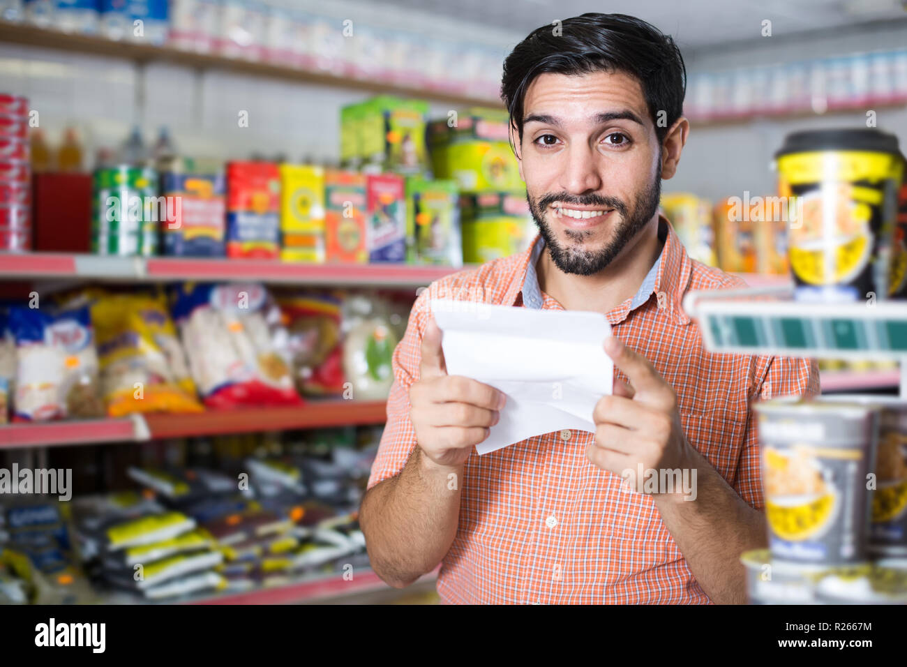 Portrait of handsome british man customer who is standing with note ...