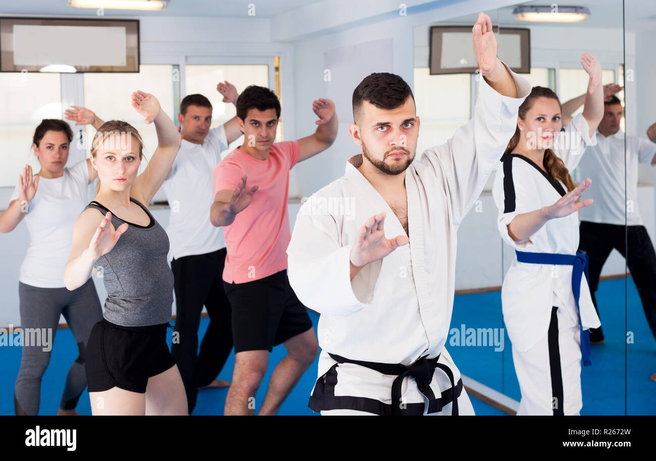 Positive people trying new martial moves in practice during karate ...