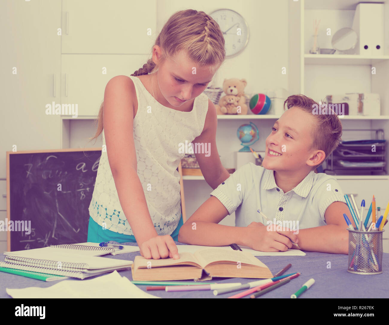 Sister is helping brother with homework at home Stock Photo - Alamy