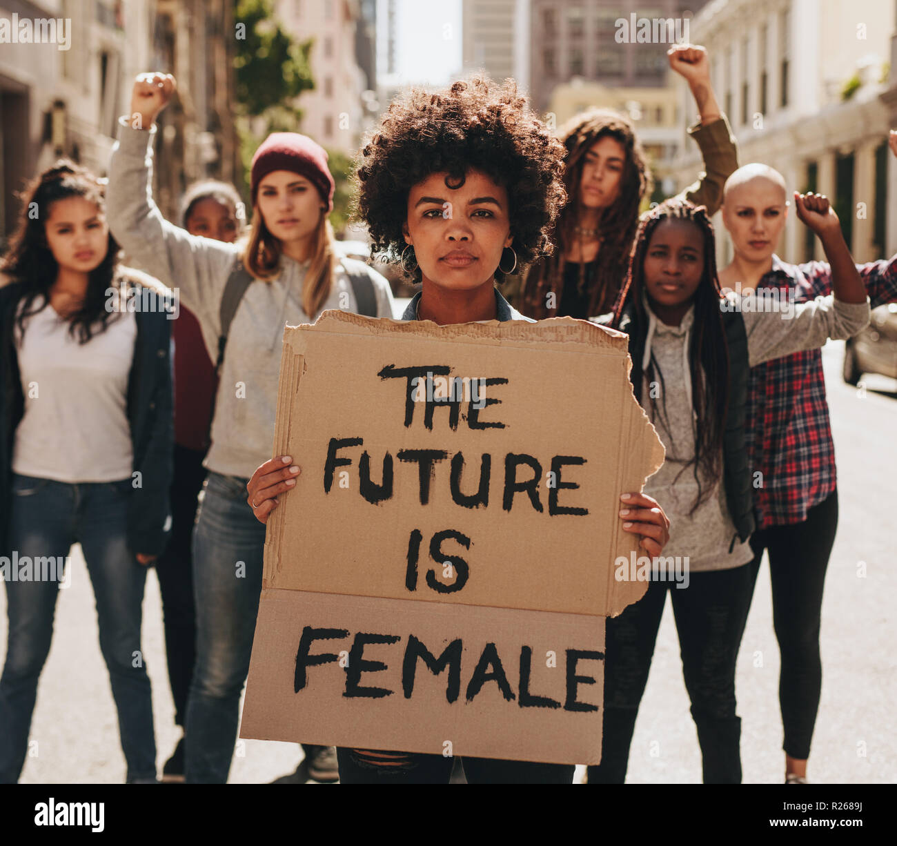 Protesters hold up signs of the future is female. Group of female ...