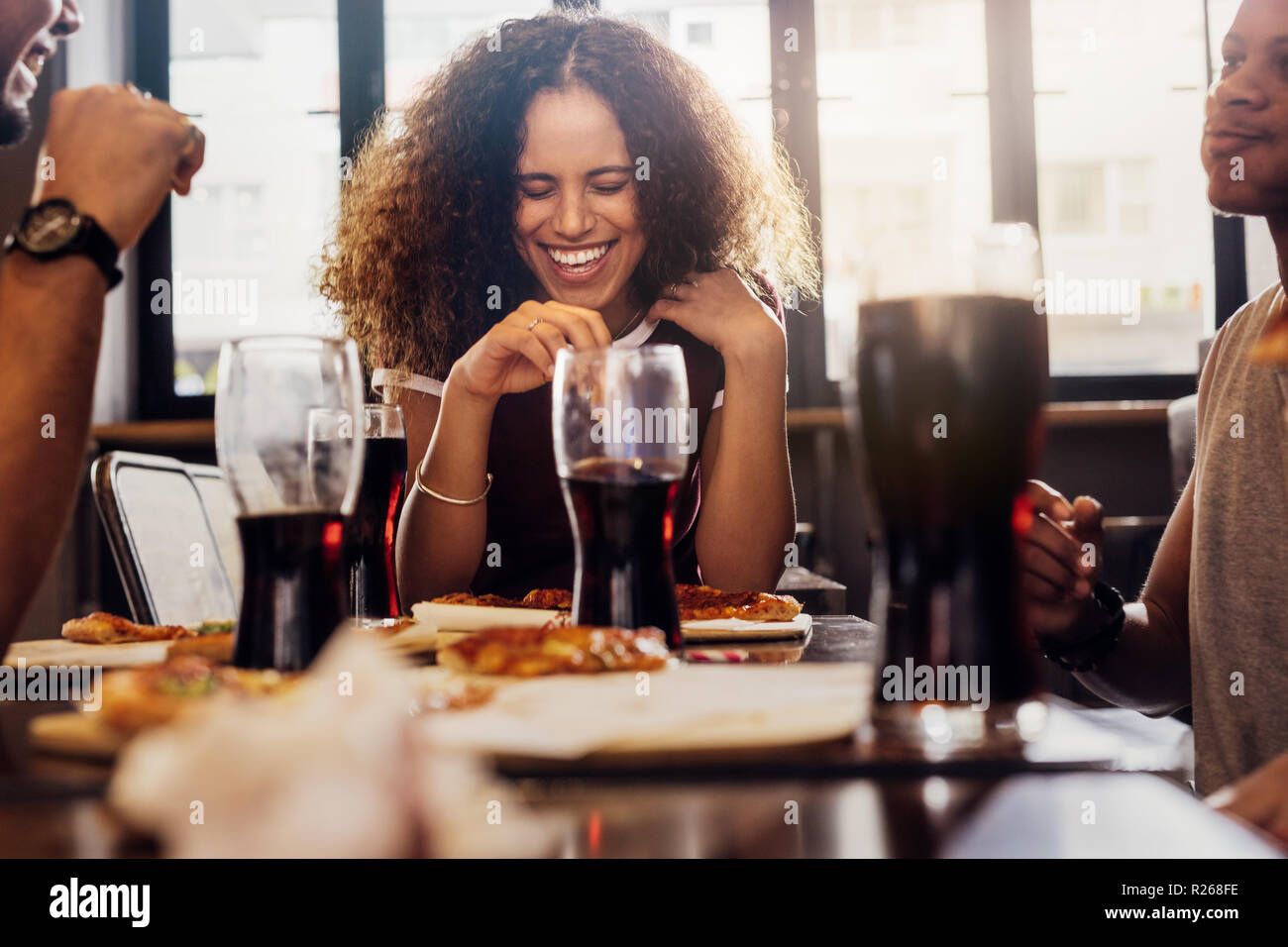 Woman sitting at restaurant with friends having fun. Woman enjoying ...