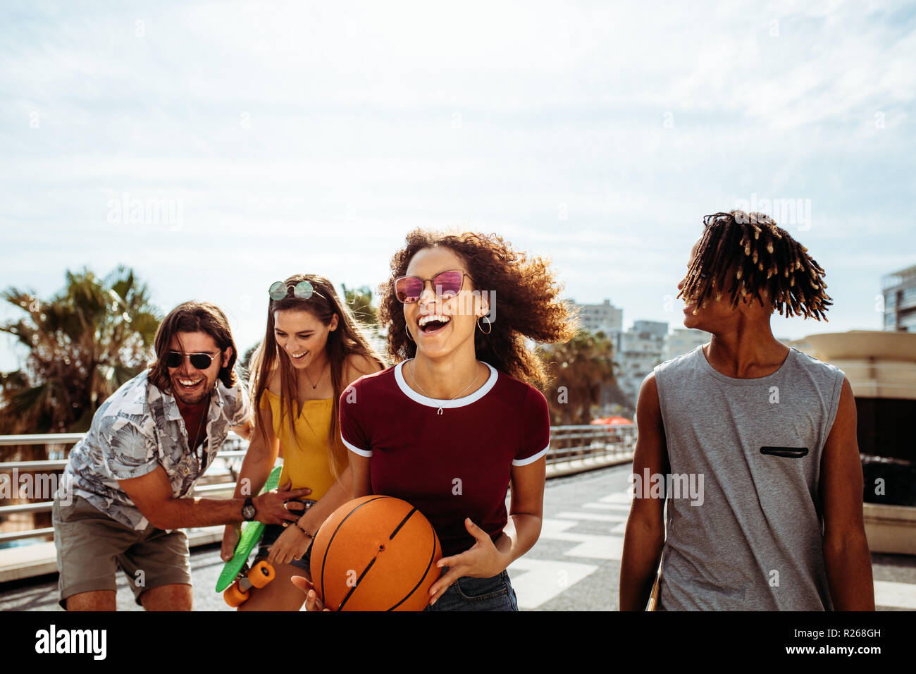 Happy young people walking together on the street outdoors. Group of ...