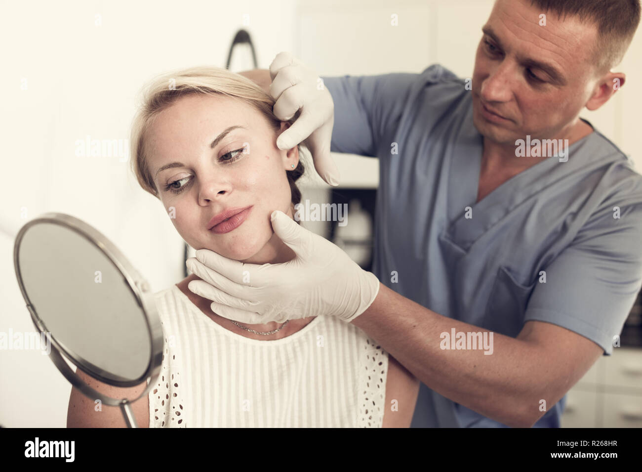 Man doctor is preparing female patient to procedure in cabinet Stock ...