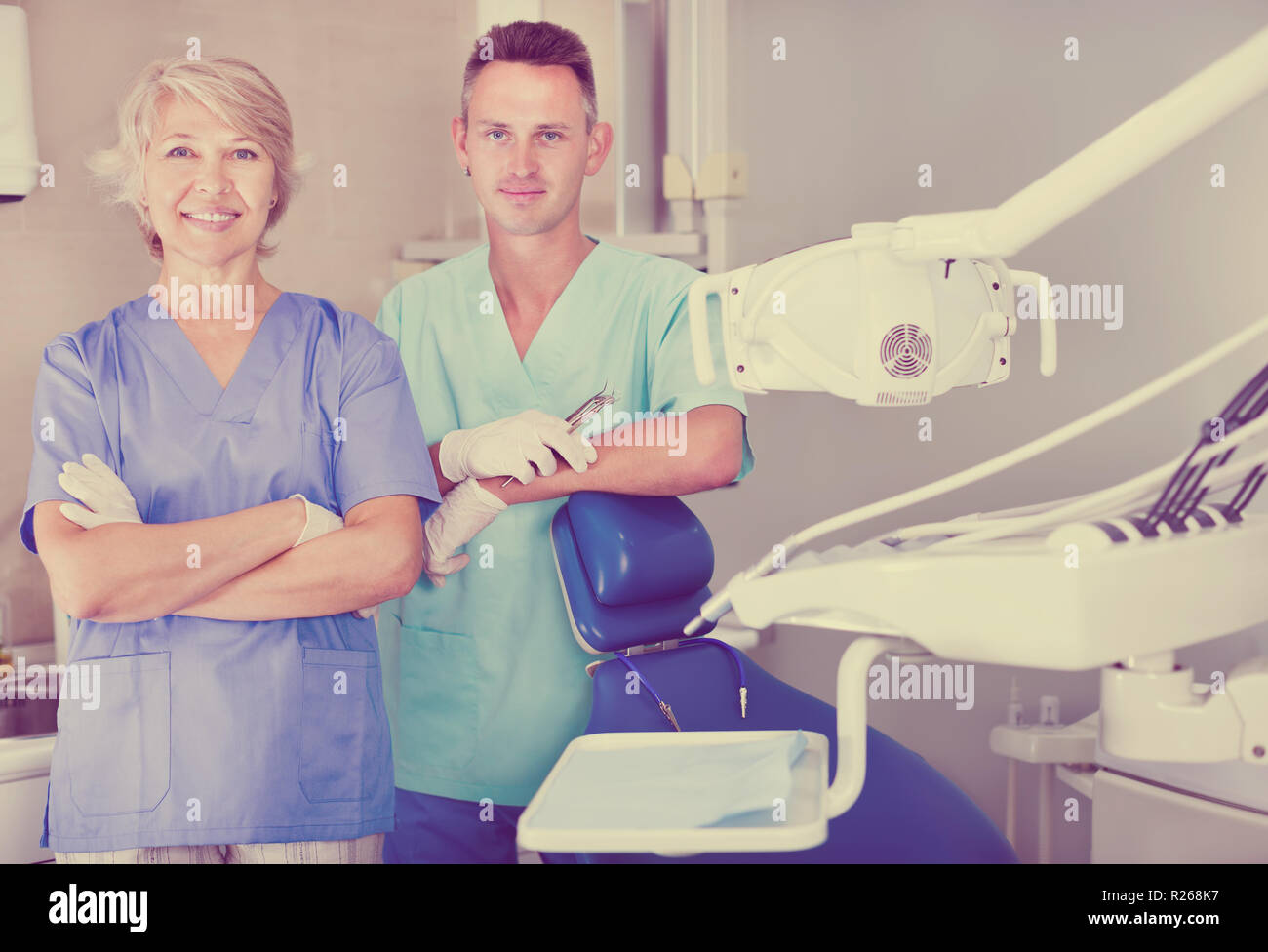 Two professional confident dentists posing near dental chair in the ...