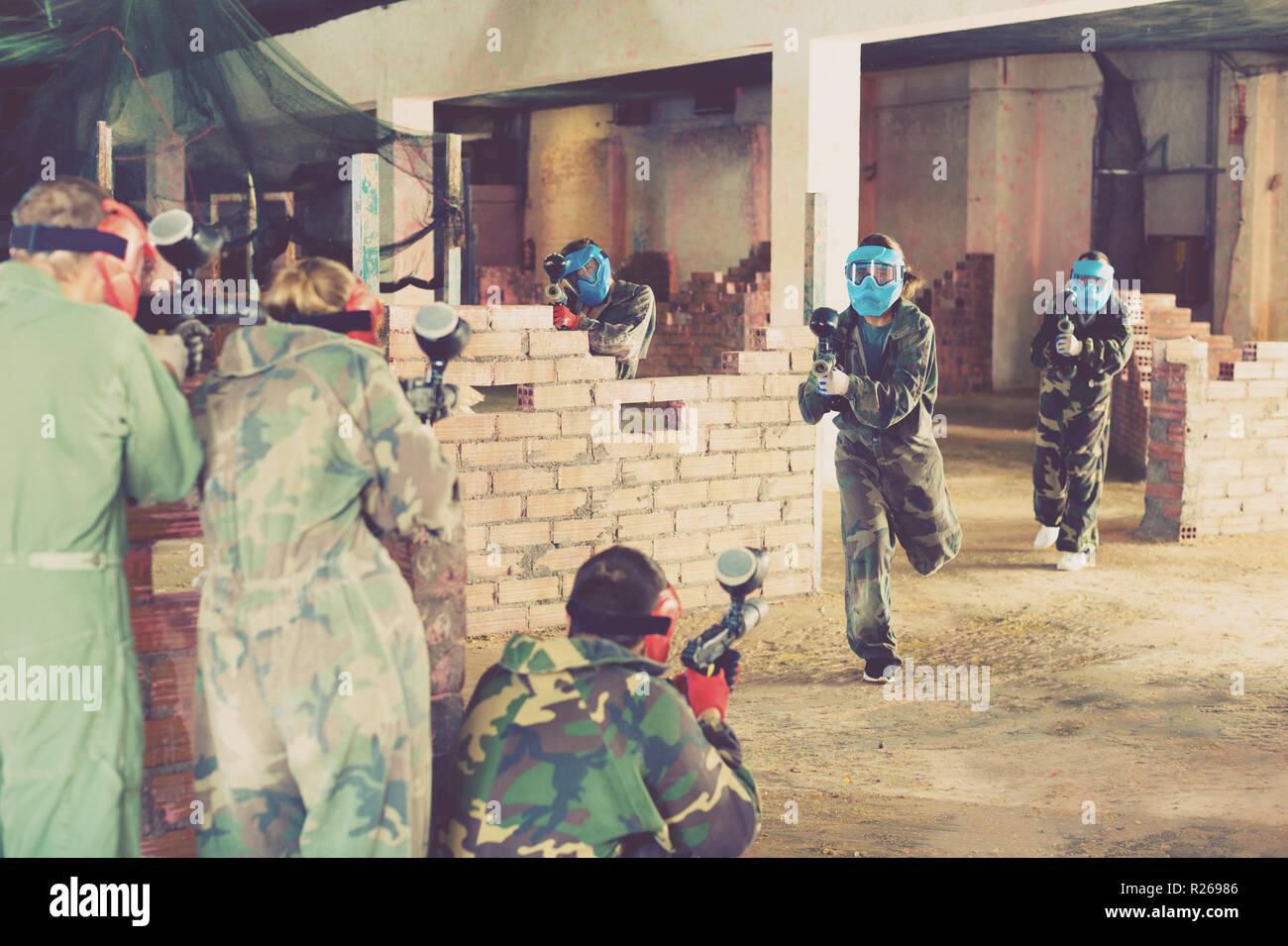 Happy positive teams faced on the battlefield in the arena of paintball ...