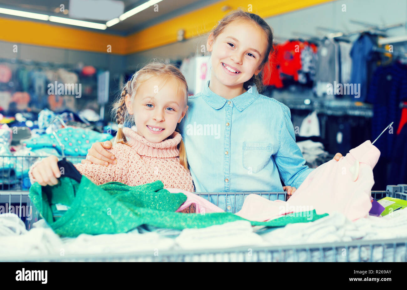 two happy little girls with new clothes in shopping mall Stock Photo ...