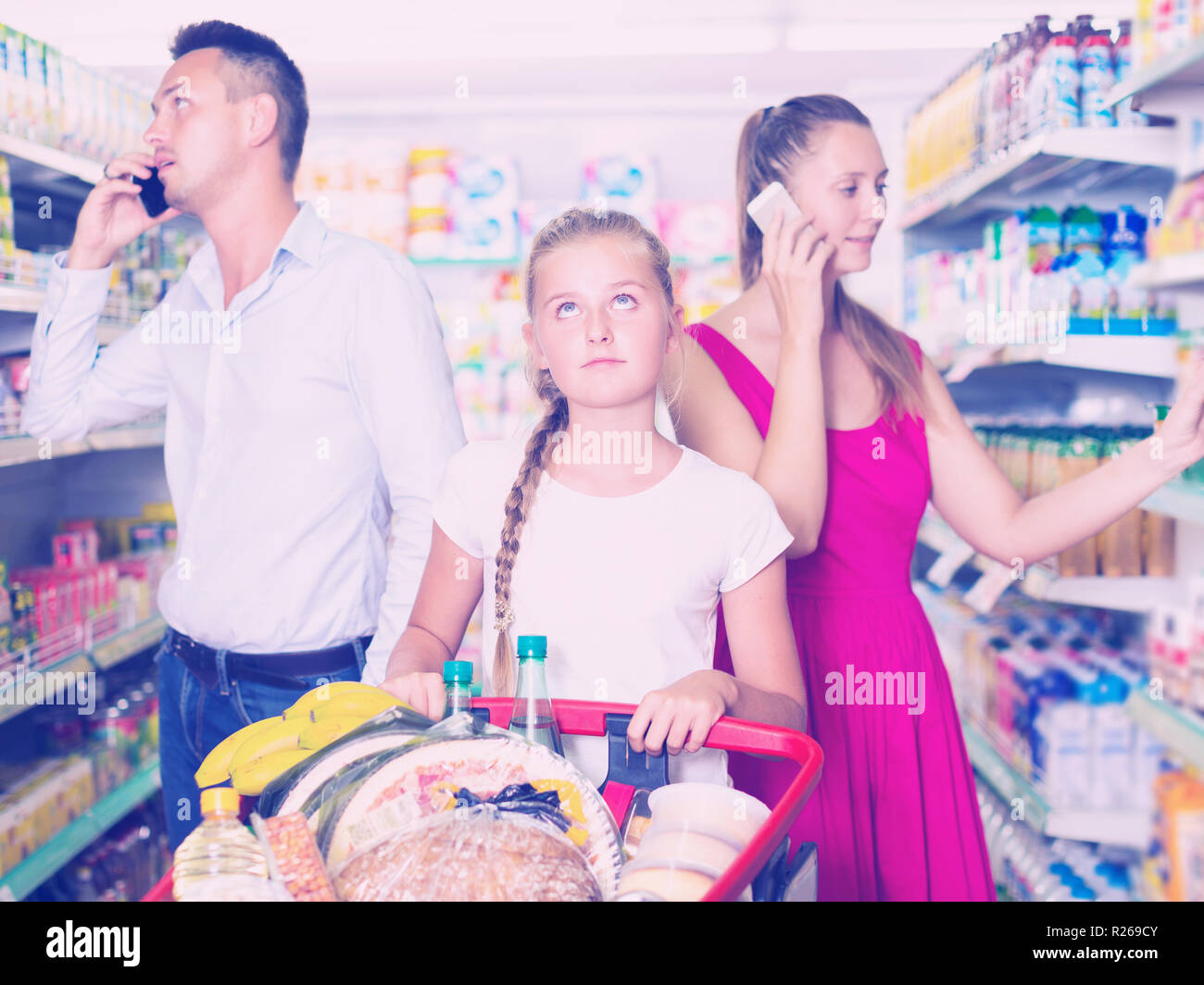 frustration kid and young parents with phones in food supermarket Stock ...