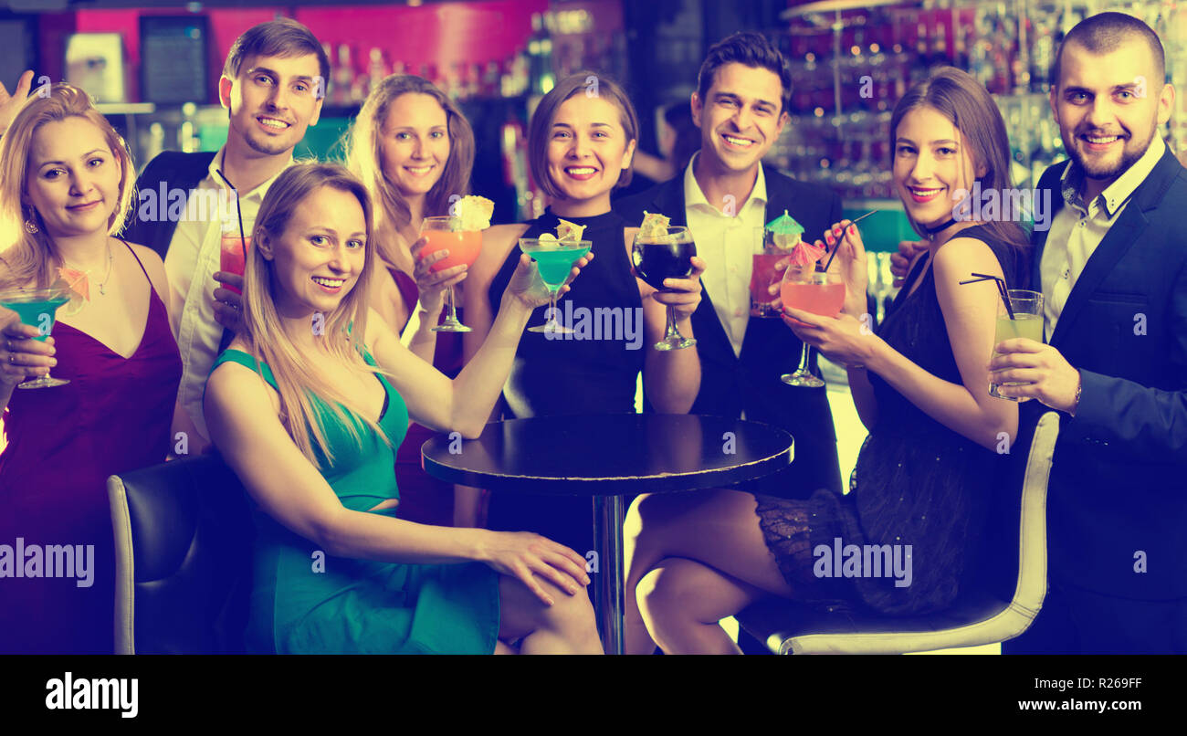 Positive colleagues dancing on corporate party with cocktails in hands ...