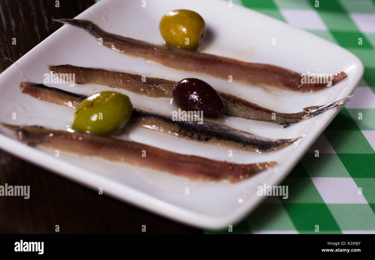 Image of plate with fish and olives in the restaurant Stock Photo - Alamy