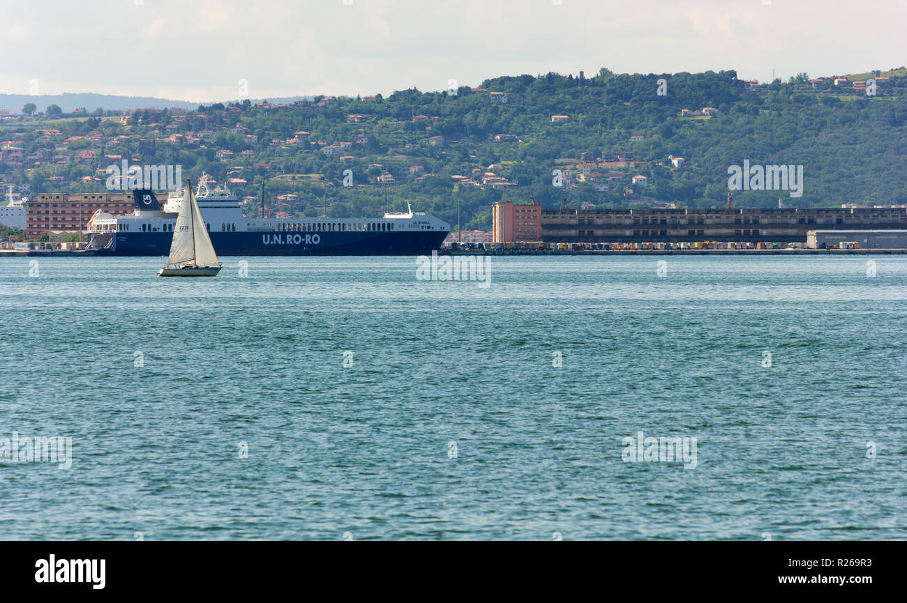TRIESTE, Italy - June 5, 2013: A sailboat in front of a docking area of ...