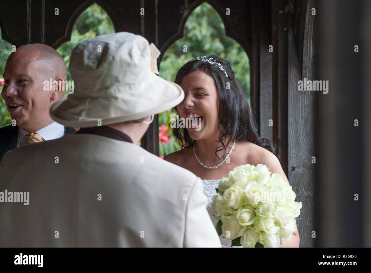 Smiling bride and groom greet and thank guests after church wedding ...