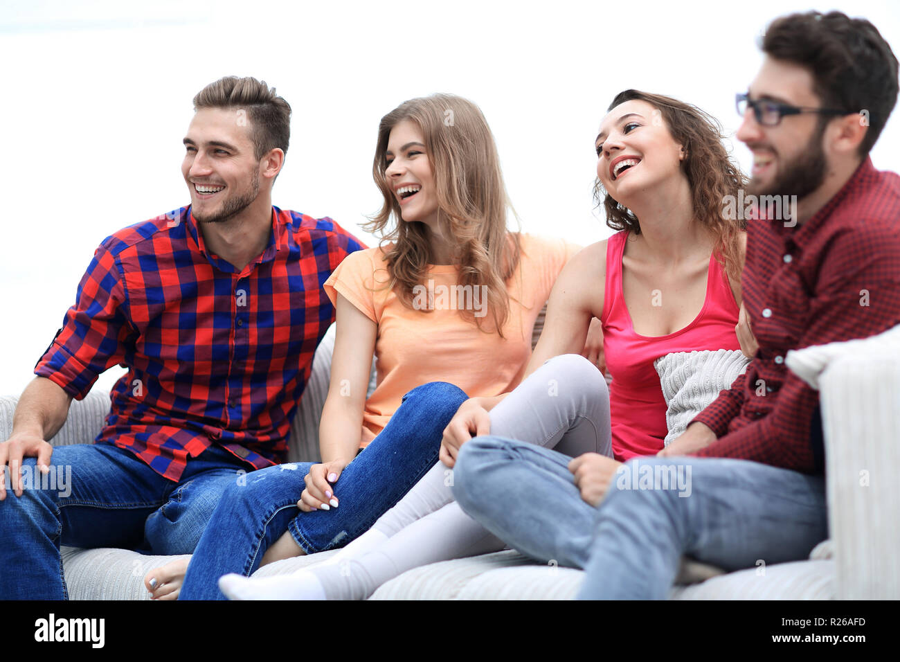 young friends sitting on the couch and rooting for their favorite team ...